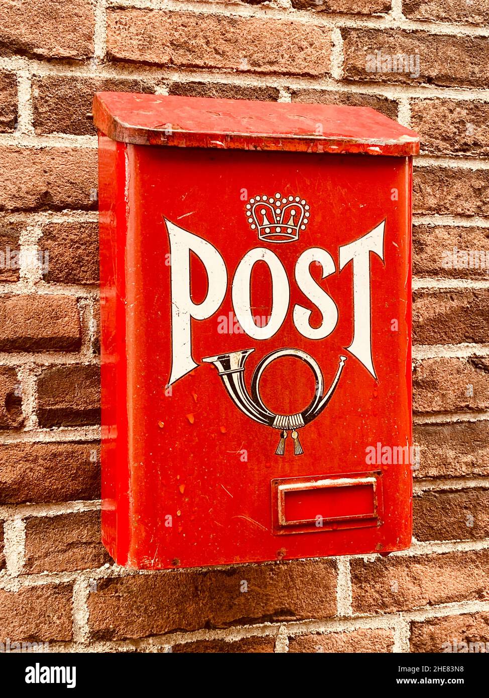 Traditional old bright red metal post box with word and picture of horn ...