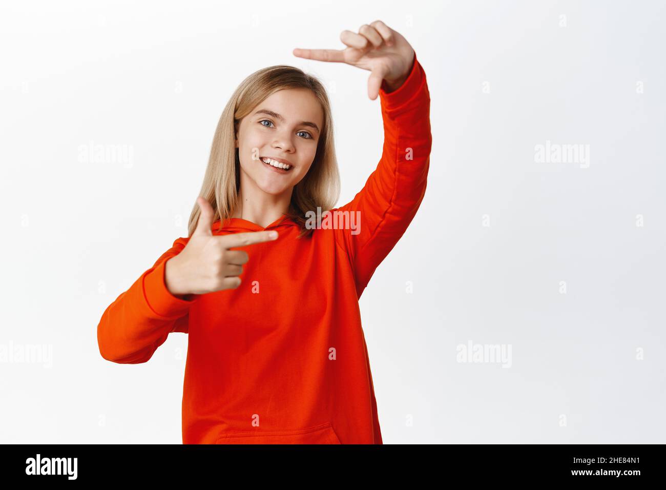 Beautiful happy child imaging smth, little girl looks through hand ...