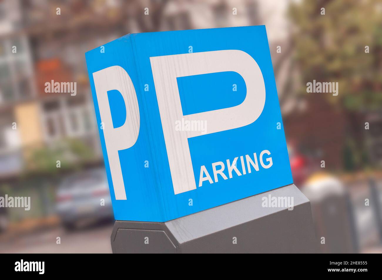 Blue parking sign with parked blurry car background Stock Photo - Alamy