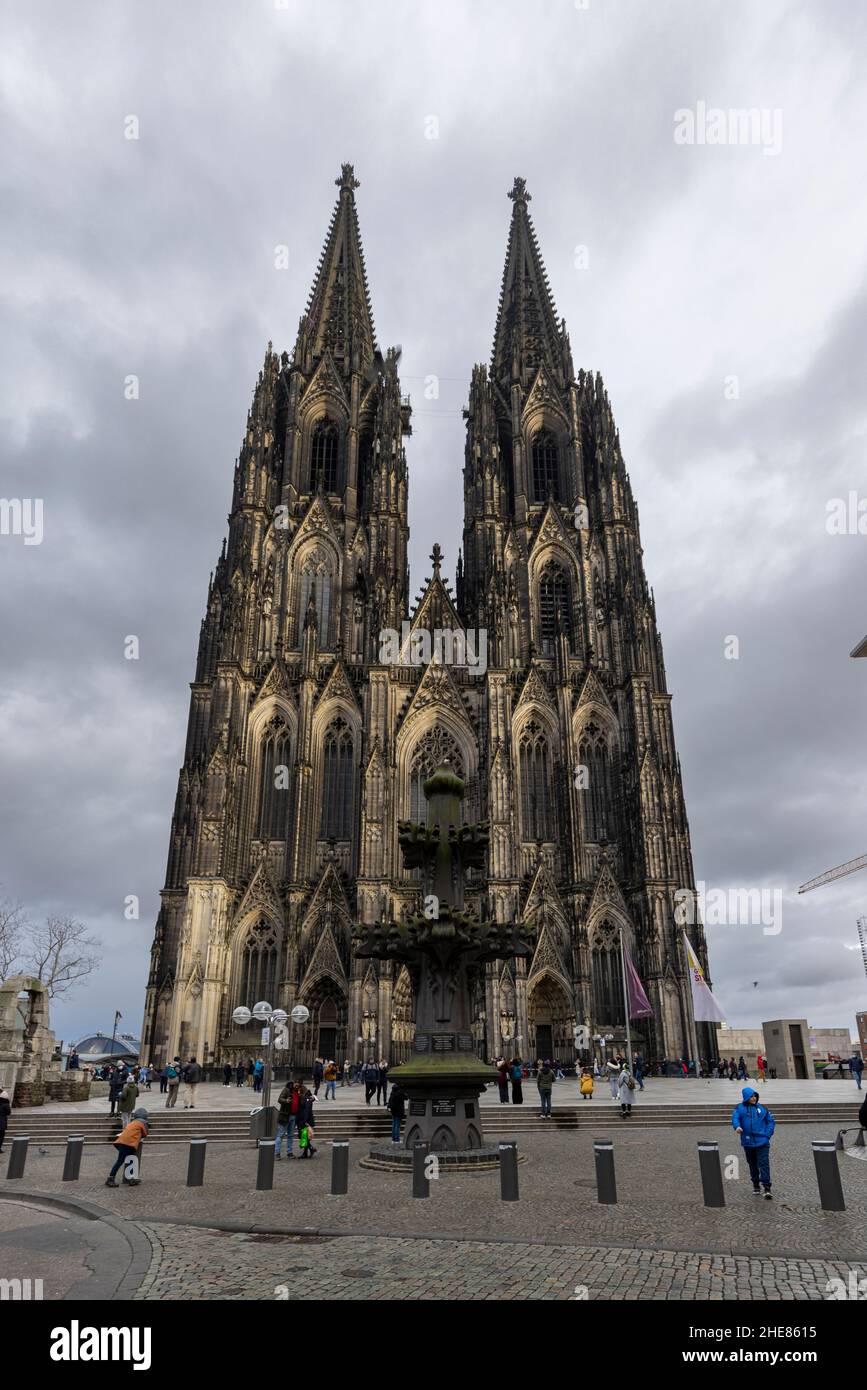Cologne Cathedral on brisk winter day with tourist walking in front ...