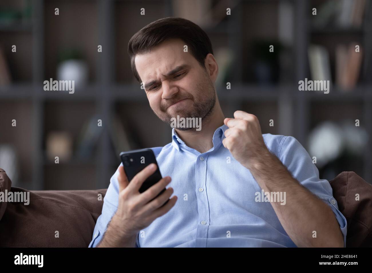 Head shot of unhappy angry man having problem with smartphone Stock ...