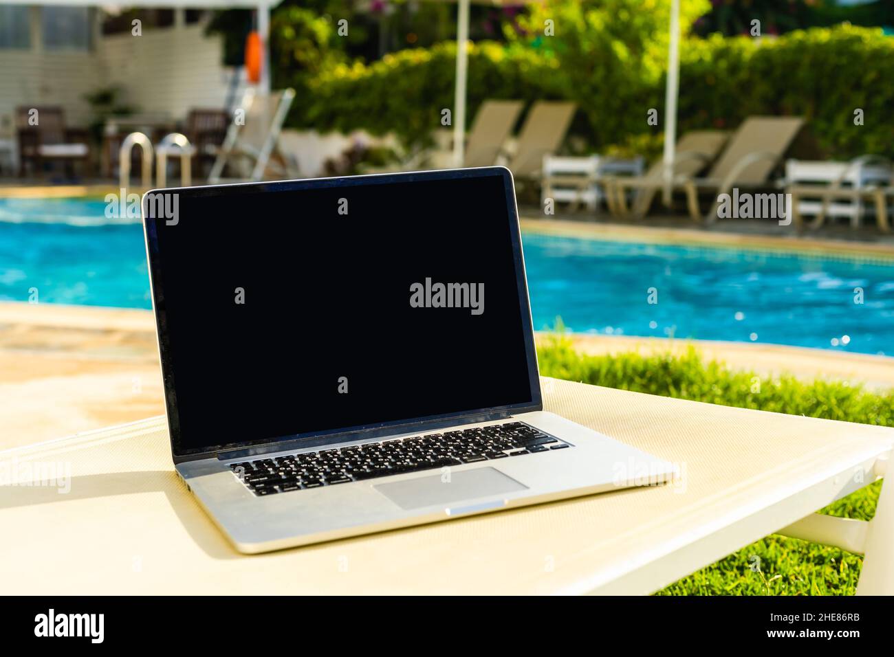 laptop computer on table pool background Stock Photo - Alamy
