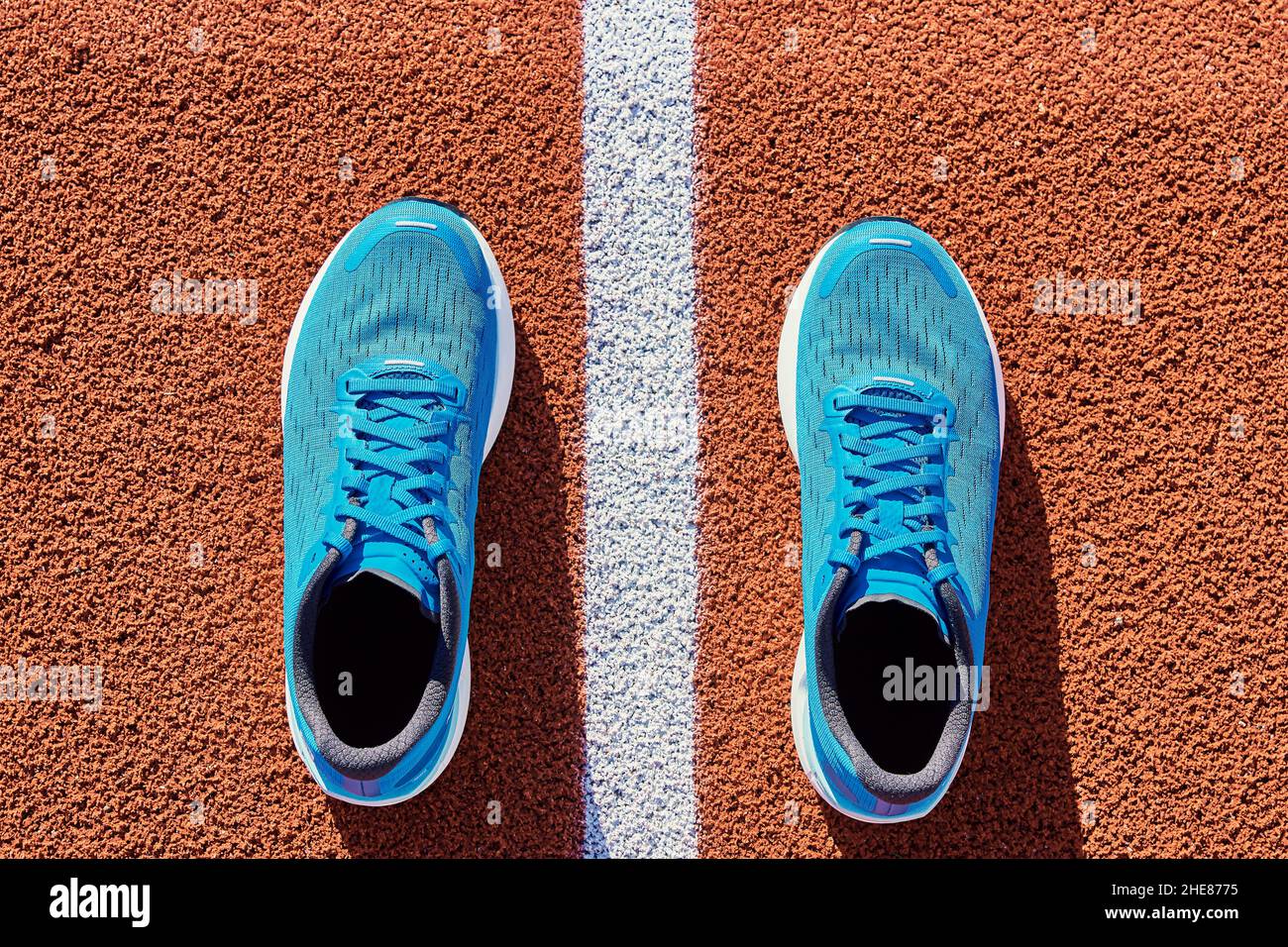 Top view of blue male running sneakers near start line at stadium track ...
