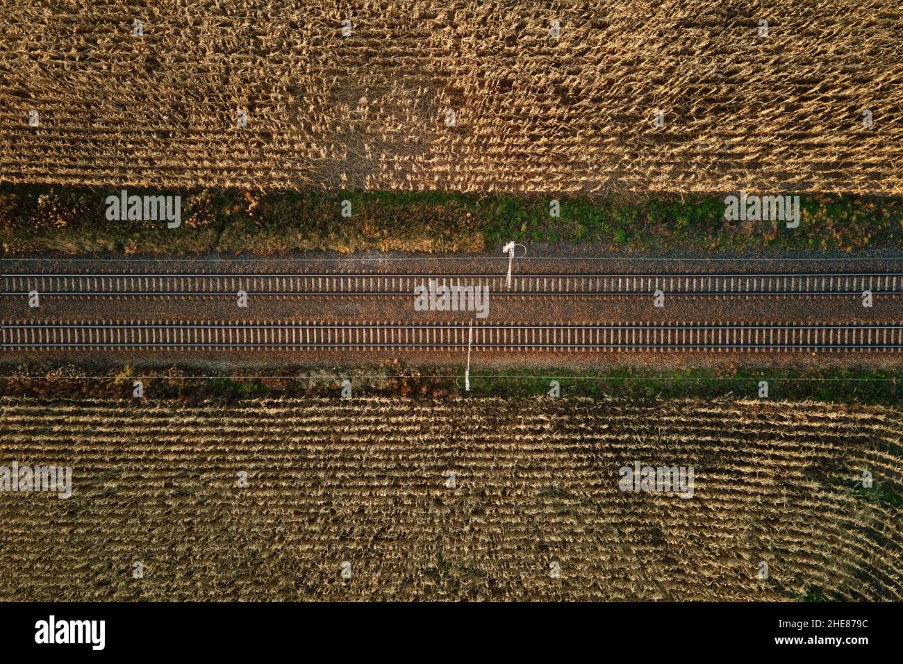 Aerial view of railway through agricultural fields at sunset ...