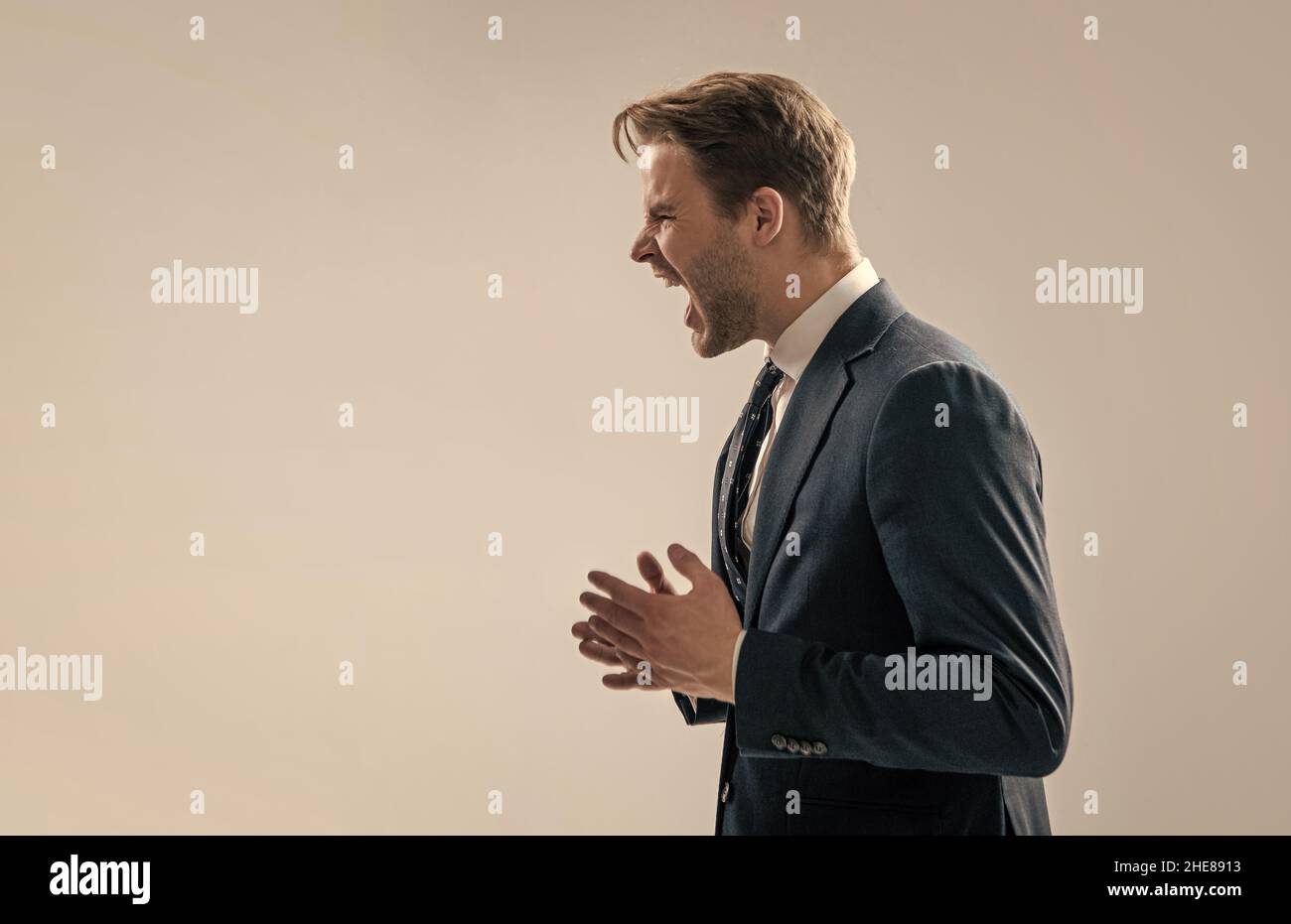 Yelling and screaming. Angry businessman scream grey background ...