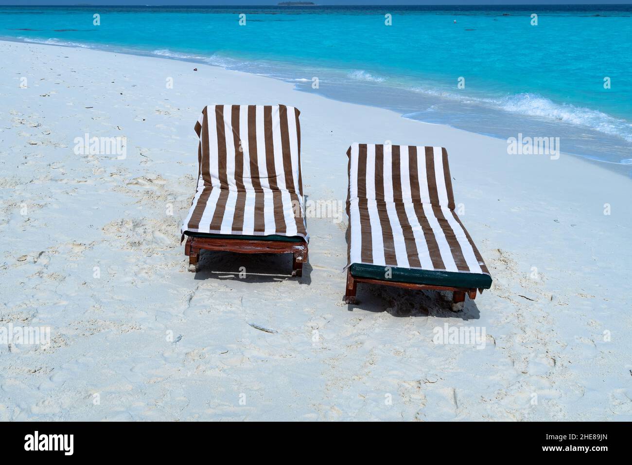 A close-up of sunbeds set on a beautiful tropical beach. Impressive ...