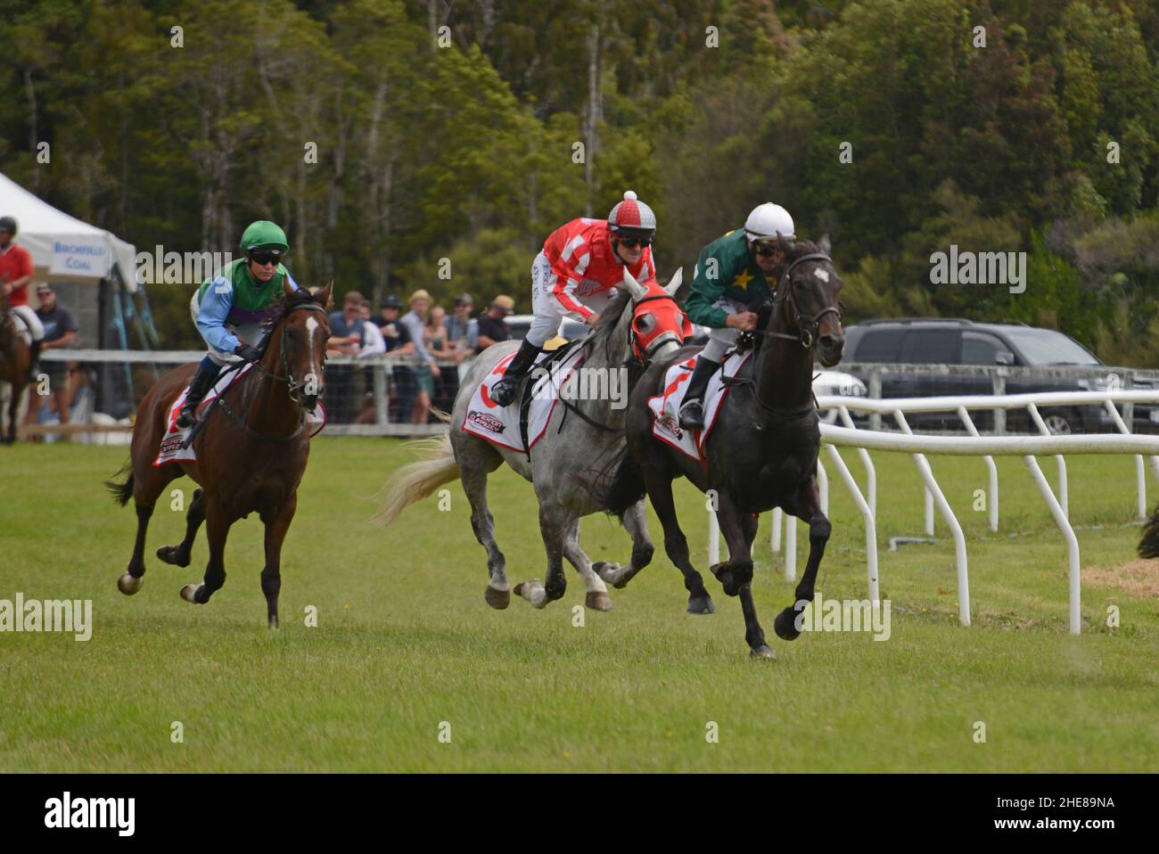 KUMARA, NEW ZEALAND, JANUARY 8, 2022; jockeys ride their mounts hard to the finish line in a ...
