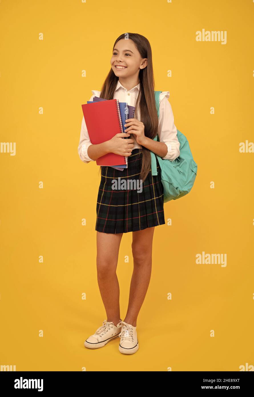 happy child with backpack and workbook in school uniform full length on ...