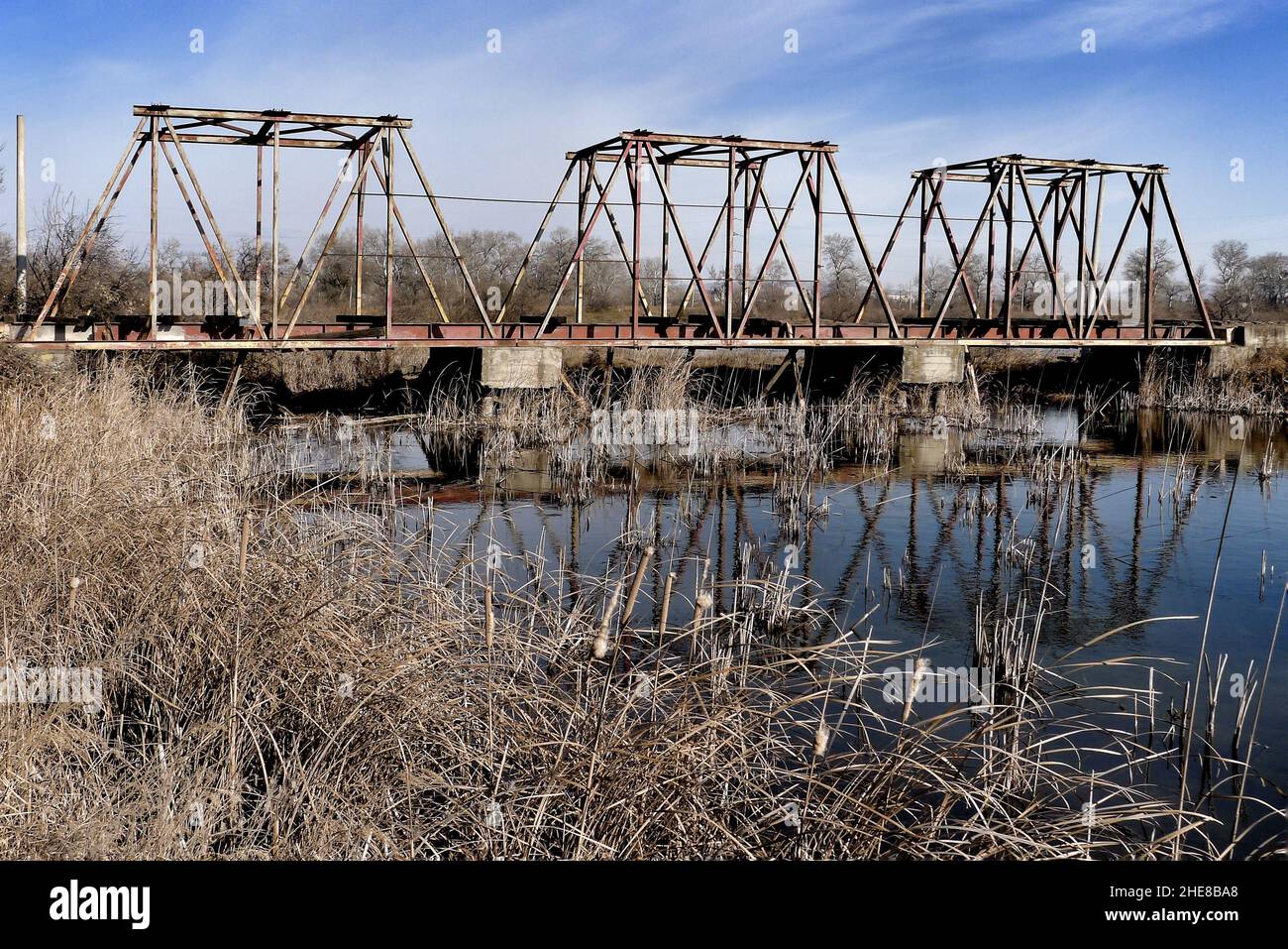 Open metal tunnel on the bridge. Cuckoo railway over the swamp Stock ...