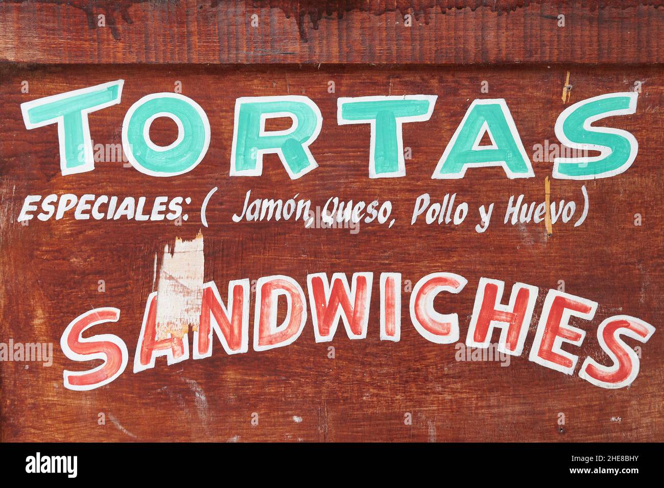 Colorful hand painted sign advertising Tortas and Sandwiches in front ...