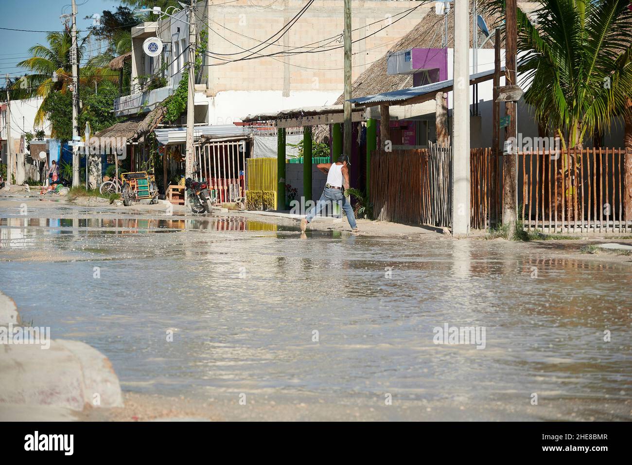 Man crossing flooded street on Isla Holbox, Mexico Stock Photo - Alamy