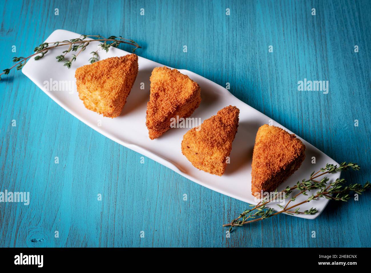 Fried Camembert cheese in portions presented on a tray and on a light ...