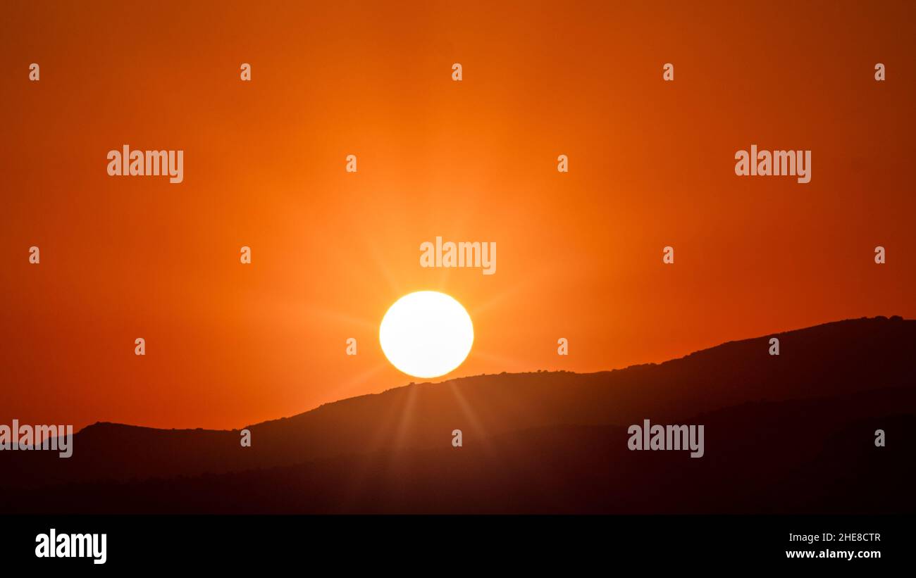 Beautiful And Extremely Orange Sunrise Over Hills Stock Photo - Alamy
