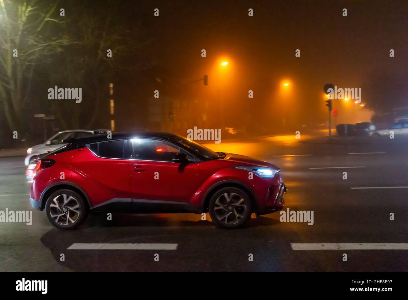 Red Car On Night Intersection Stock Photo - Alamy
