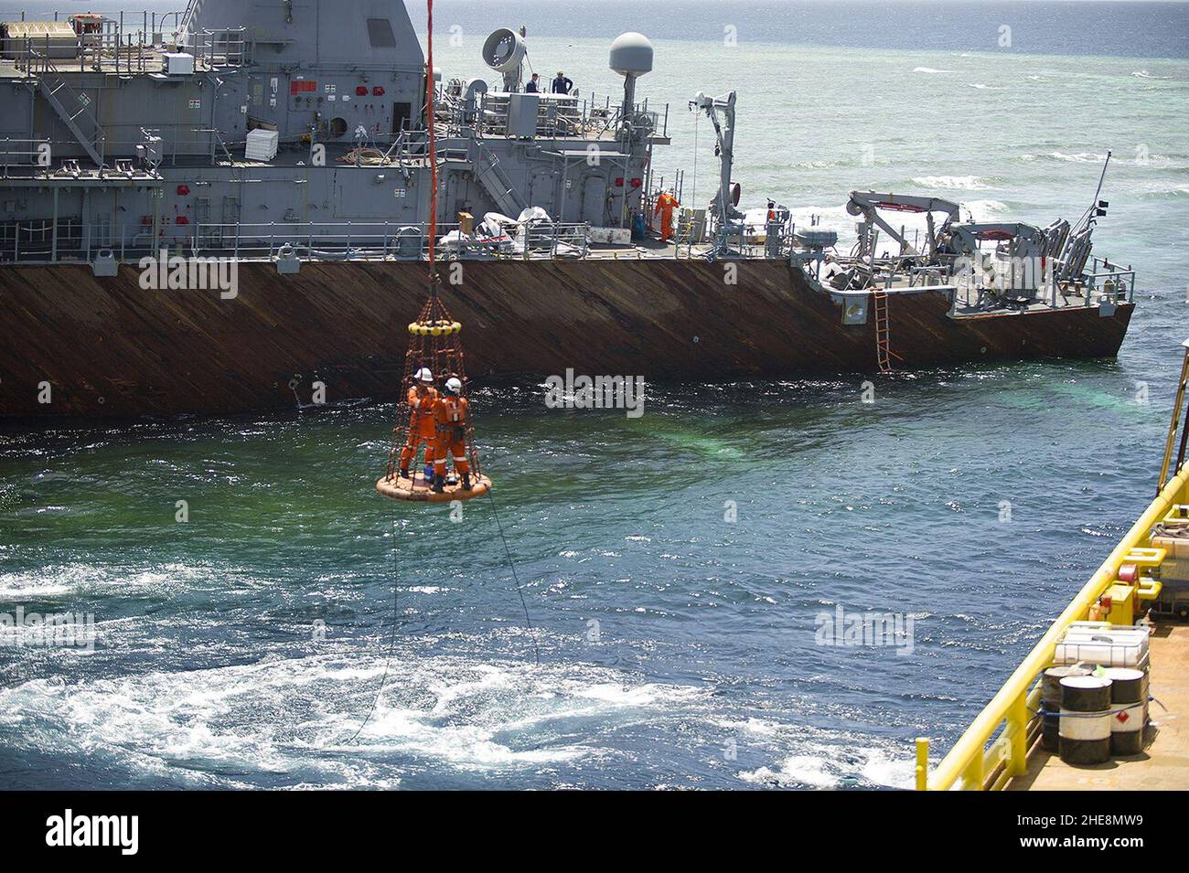 Salvage crew members are craned to USS Guardian. (8516137246 Stock ...