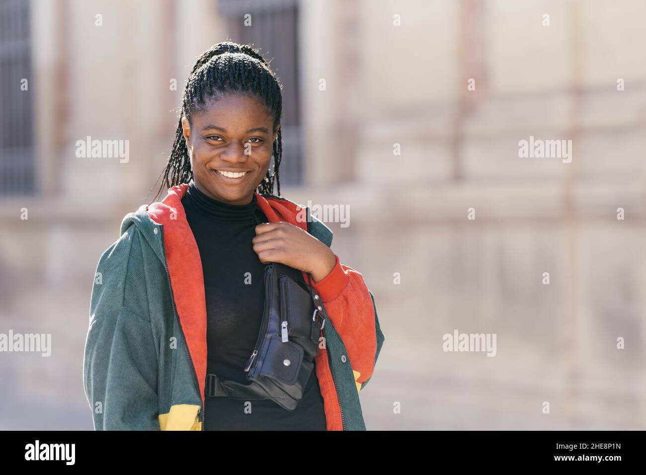 African woman with a fanny pack smiling at the camera outdoors Stock ...