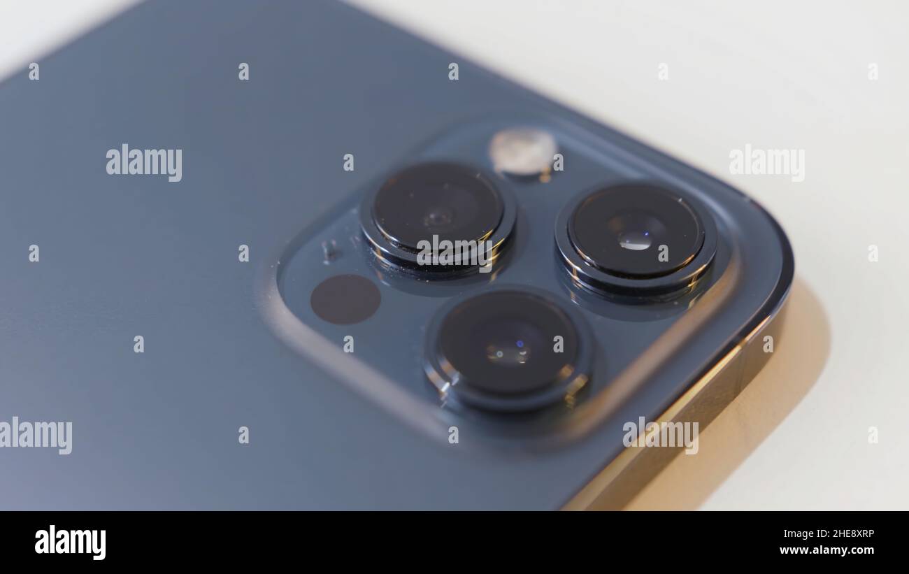 Close up details of a beautiful dark blue smartphone with three cameras ...