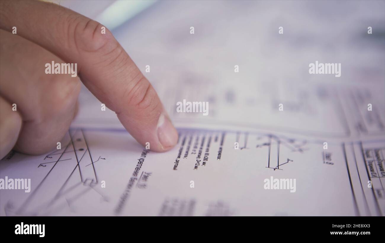 Close up view on engineer hand pointing at technical drawings. Men ...