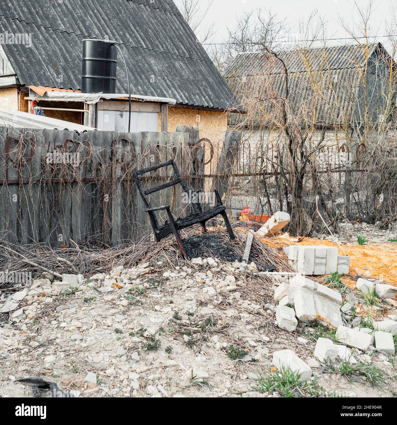 Burnt chair, similar to the throne, standing on a pile of construction ...