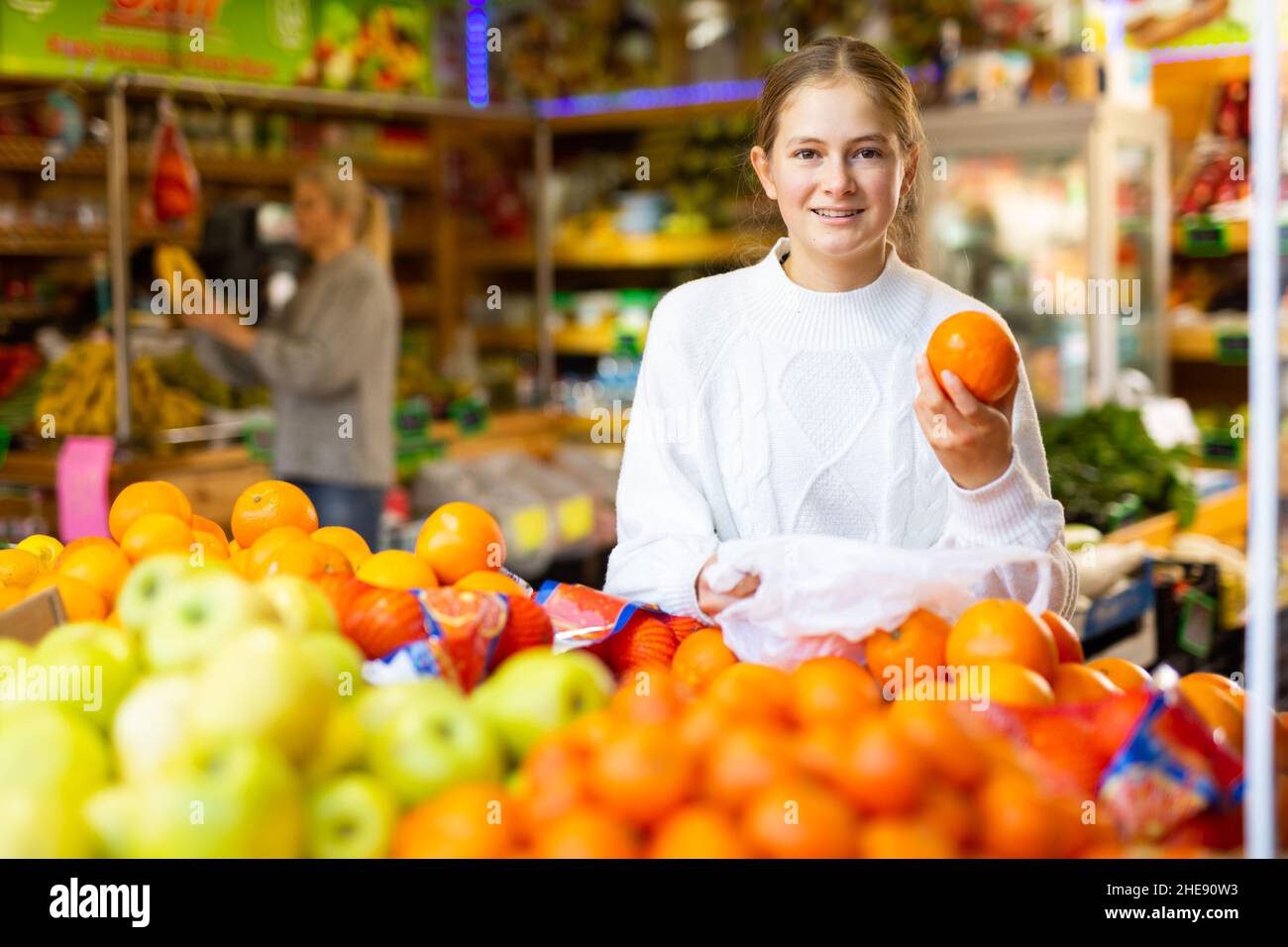 Portrait of teenage girl customer buying sweet oranges at shop Stock ...