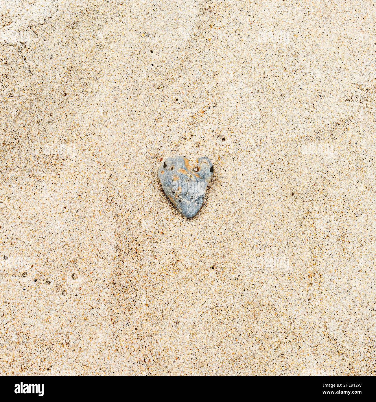 Heart-shaped gray sea rock on sandy beach, square photo Stock Photo - Alamy