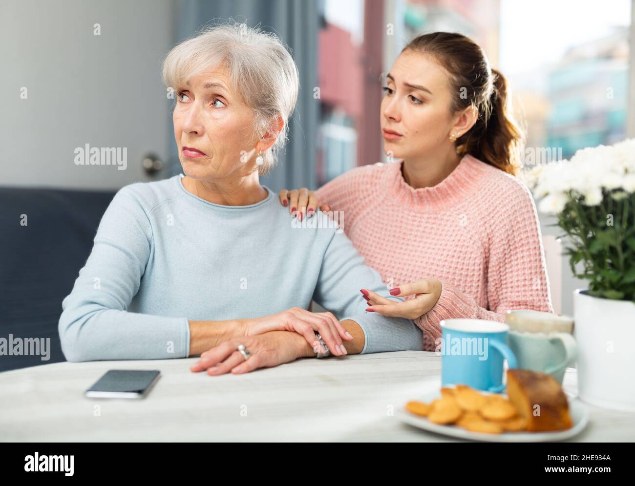 Young woman encouraging her upset mother Stock Photo - Alamy
