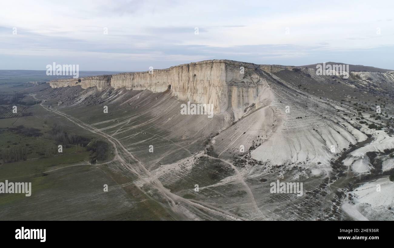 Aerial top view for breathtaking white cliff near green valley on ...