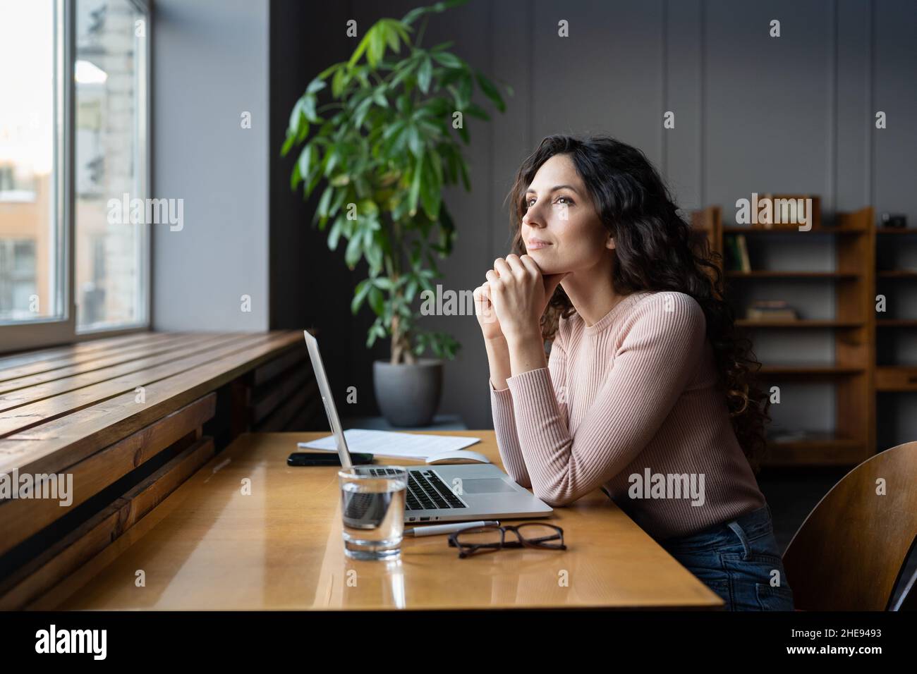 Wellbeing at work. Young dreamy female employee enjoying good window ...