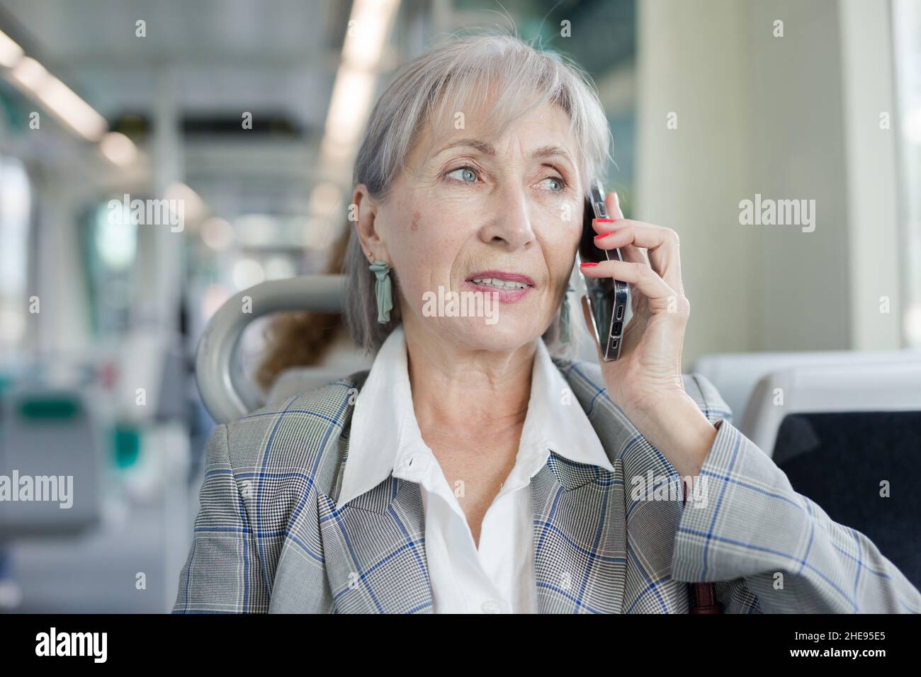 Senior woman having telephone conversation in tram Stock Photo - Alamy