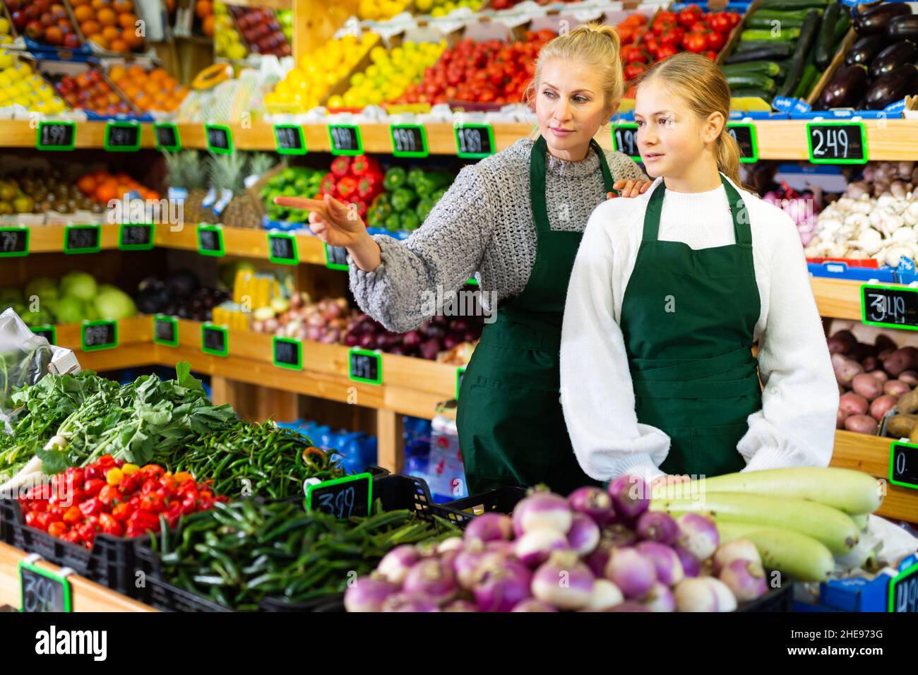 Grocery store employee points hand to young trainee girl Stock Photo ...