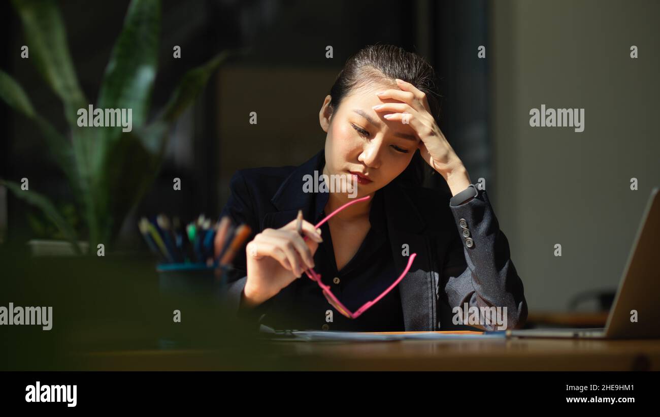 Stressed business woman working in the office. Headache, worried ...