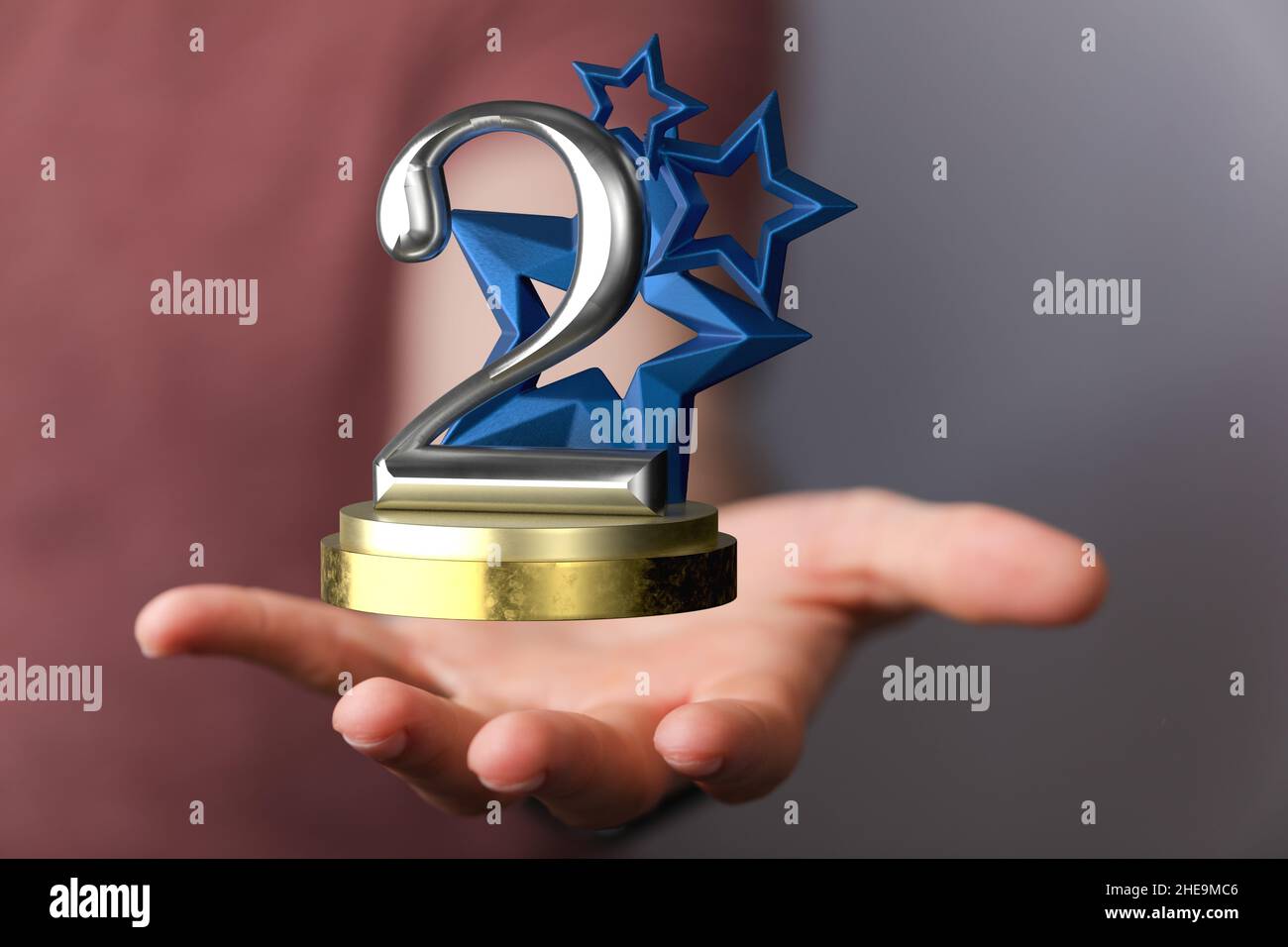Shallow focus of a human hand holding the 2nd place award, achievement ...