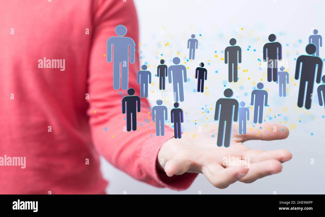 Shallow focus of a human hand holding interconnected human icons for ...