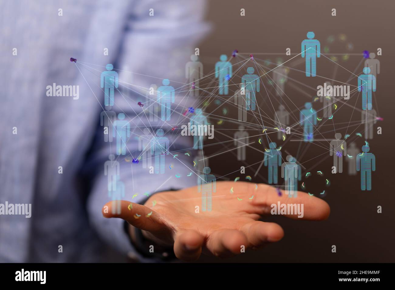Shallow focus of a human hand holding interconnected human icons for ...