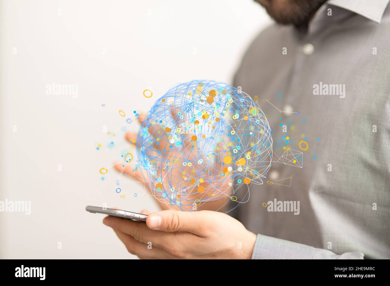 Shallow focus of human hands holding a phone and interconnected globe ...