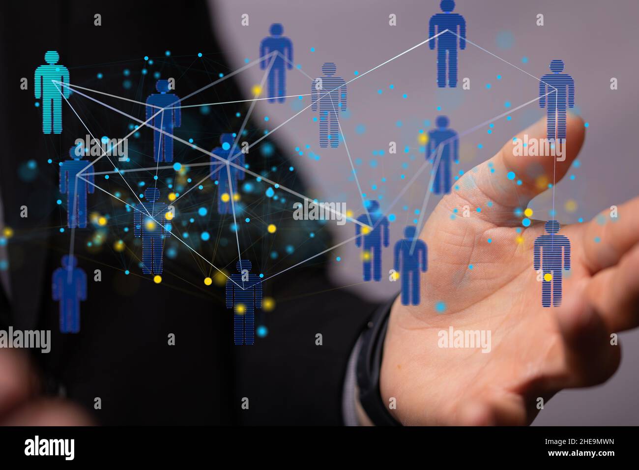 Shallow focus of a human hand holding interconnected human icons for ...