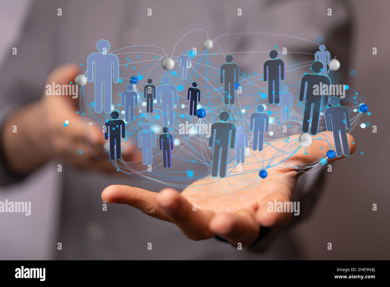 Shallow focus of human hands holding interconnected human icons for ...