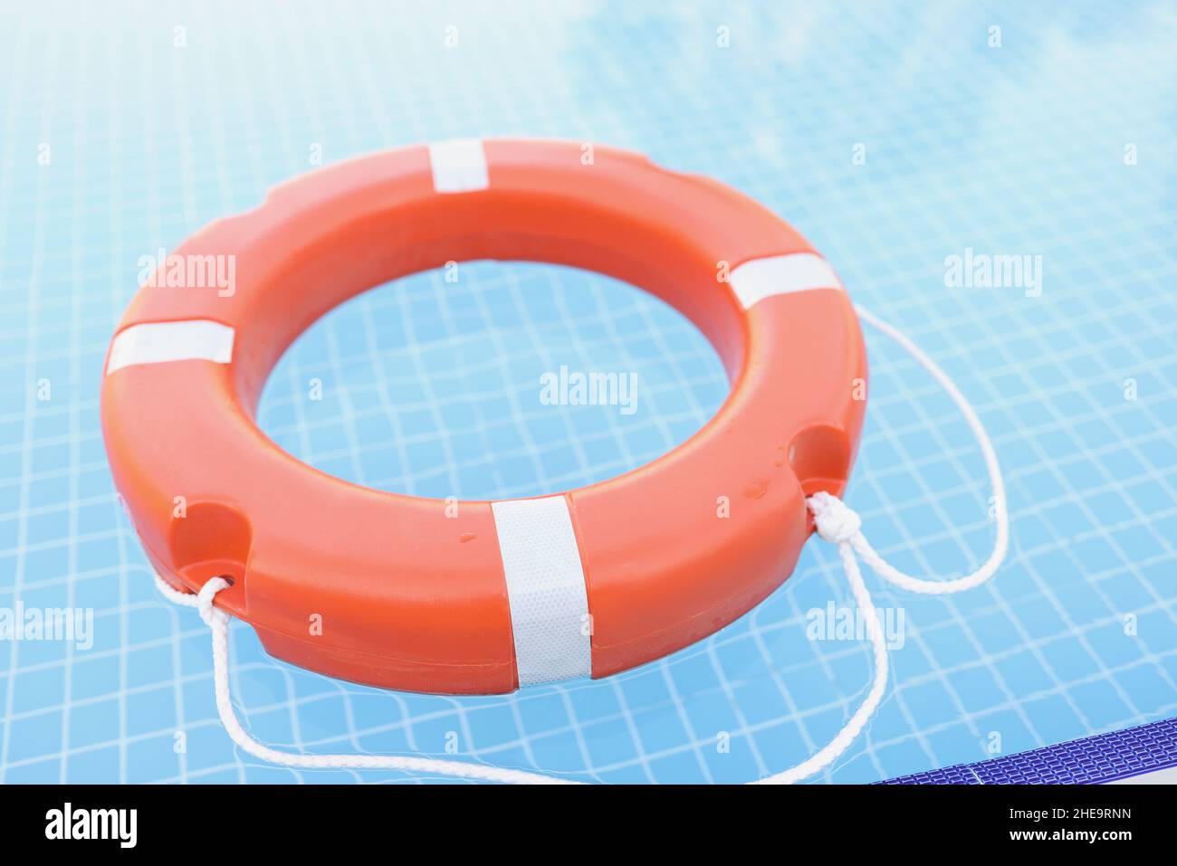 Red lifebuoy in the pool, blue water, close-up. Drowning assistance ...