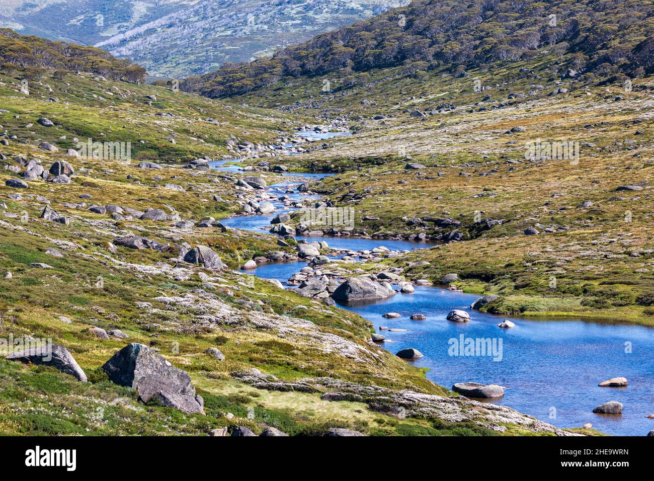Photograph of a fresh water river flowing through a green rocky valley ...