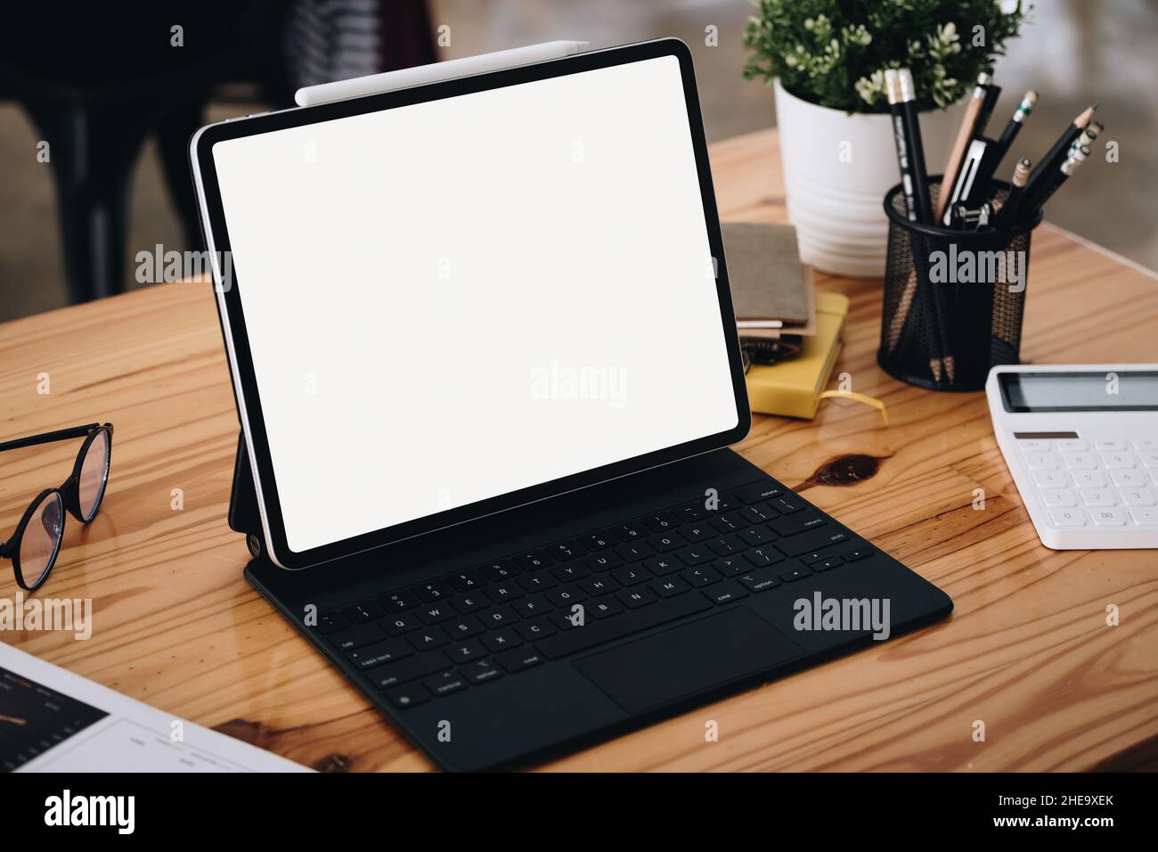 A white screen tablet computer placed on the desk at work. Can put text ...