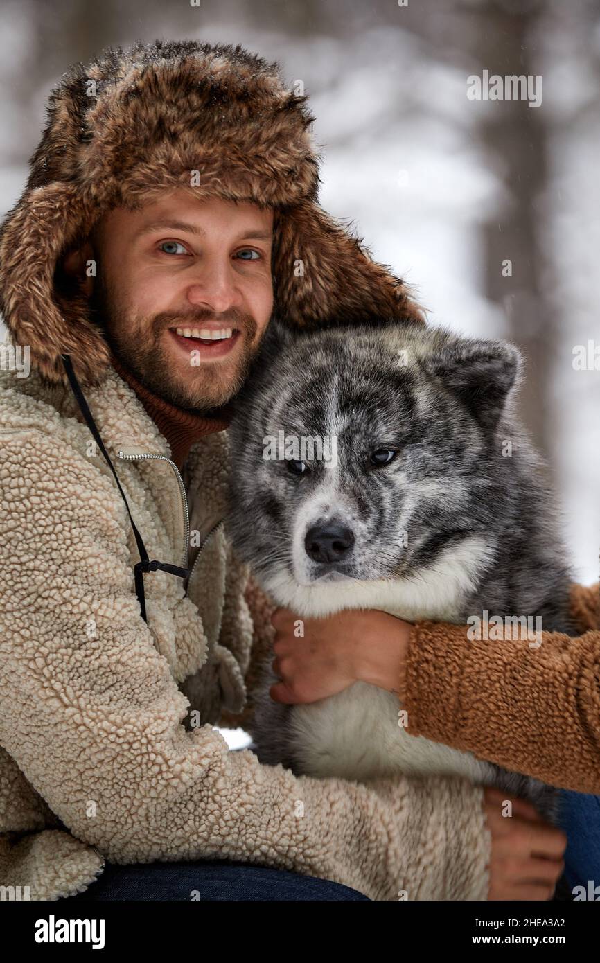 Men playing with siberian husky in winter forest and park, animals and ...