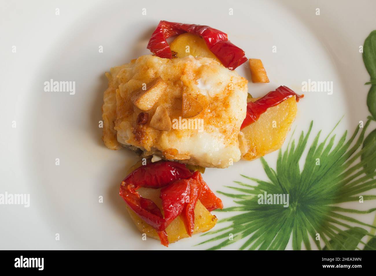 Plating of white fish varnished with toasted egg accompanied with red ...