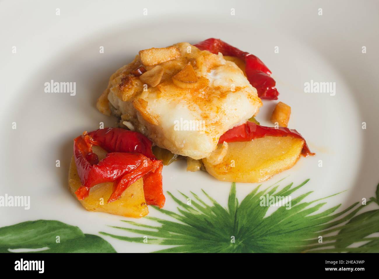 Roasted white fish cod with garlic red pepper and baked potato on a ...