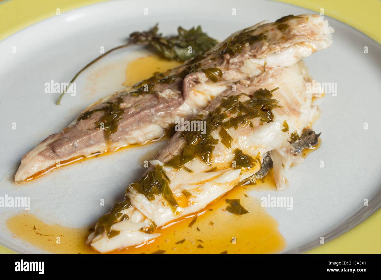 Plating of baked sea bream with a dressing of garlic sauce, vinegar ...