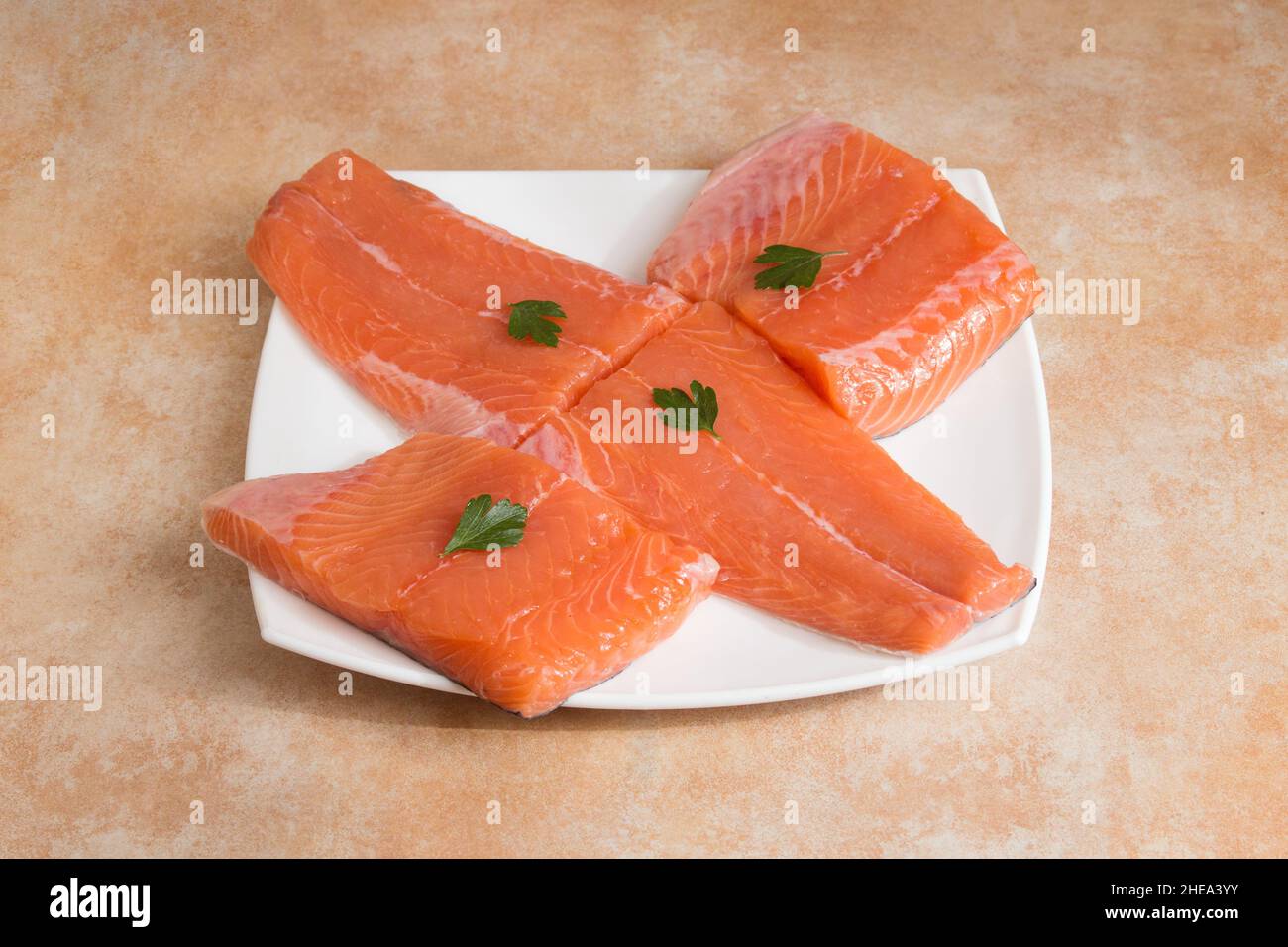 Half fresh salmon just cut into loins garnished with fresh parsley ...
