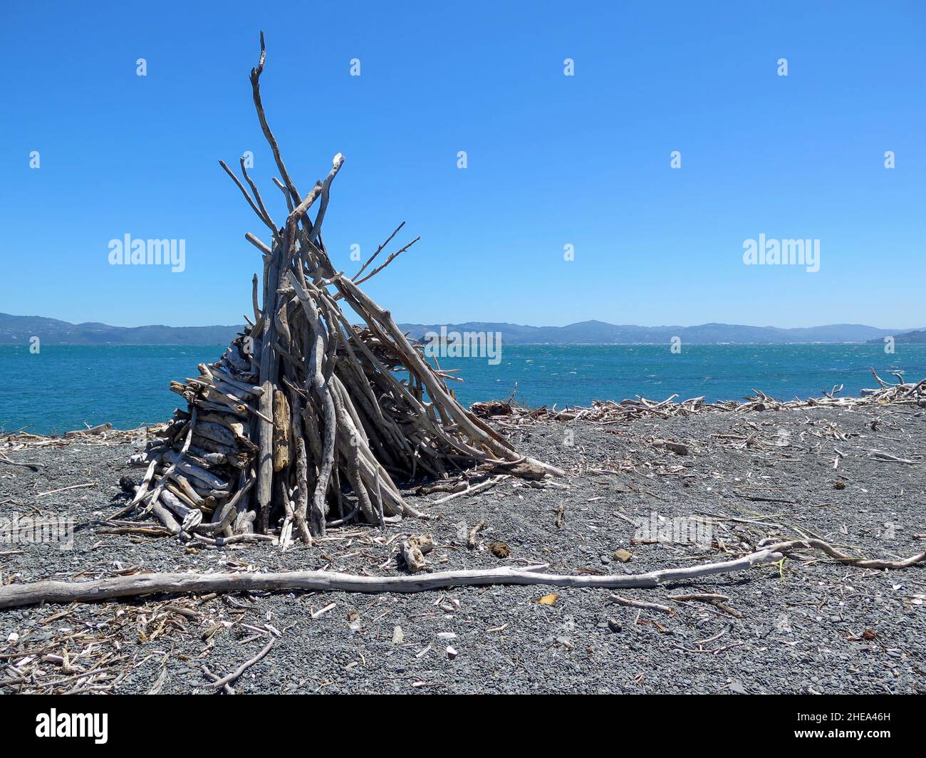 Driftwood tee pee structure on pebble beach Stock Photo - Alamy