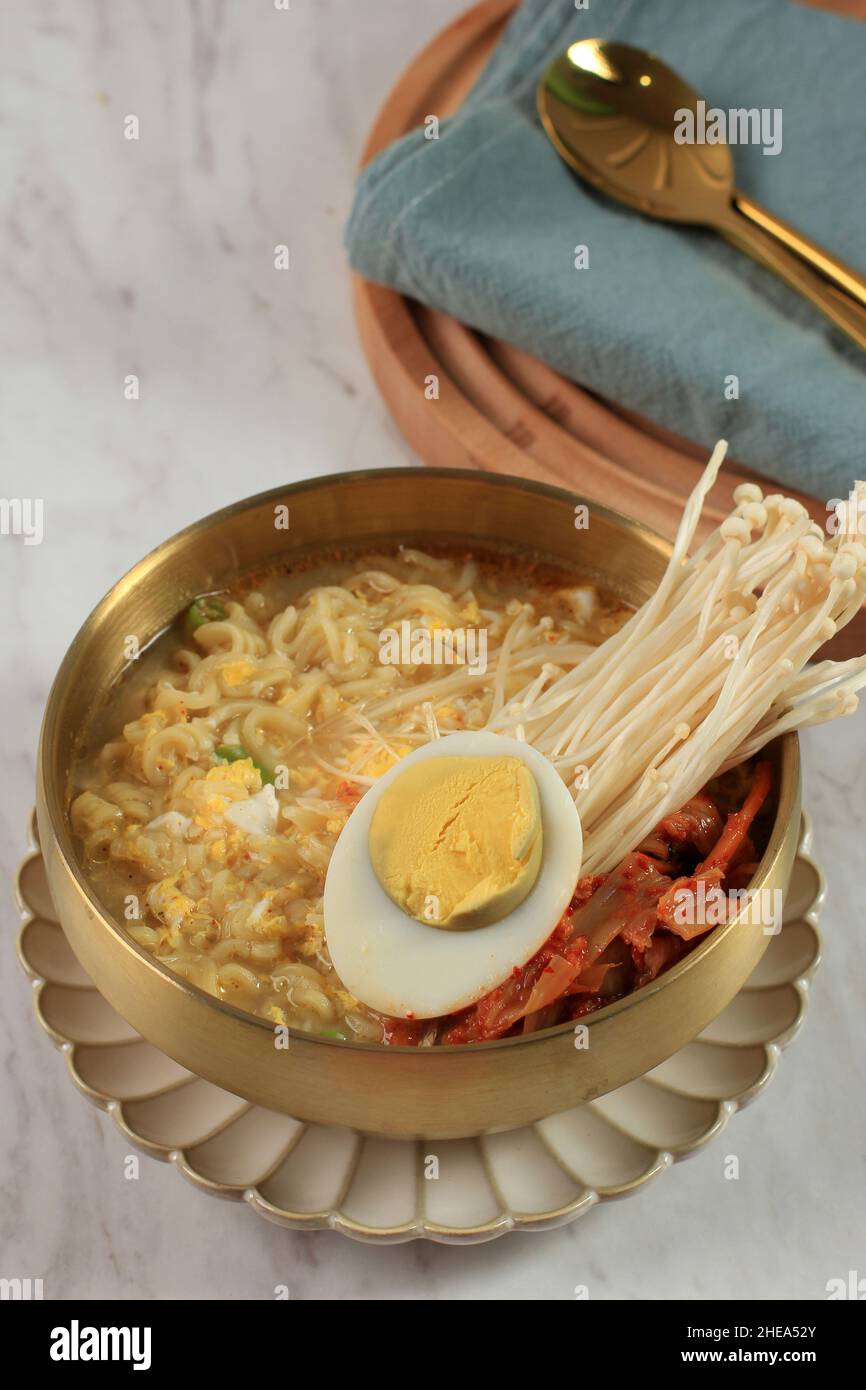 Korean traditional Ramyeon noodle with egg yolk, chilli, kimchi in a ...