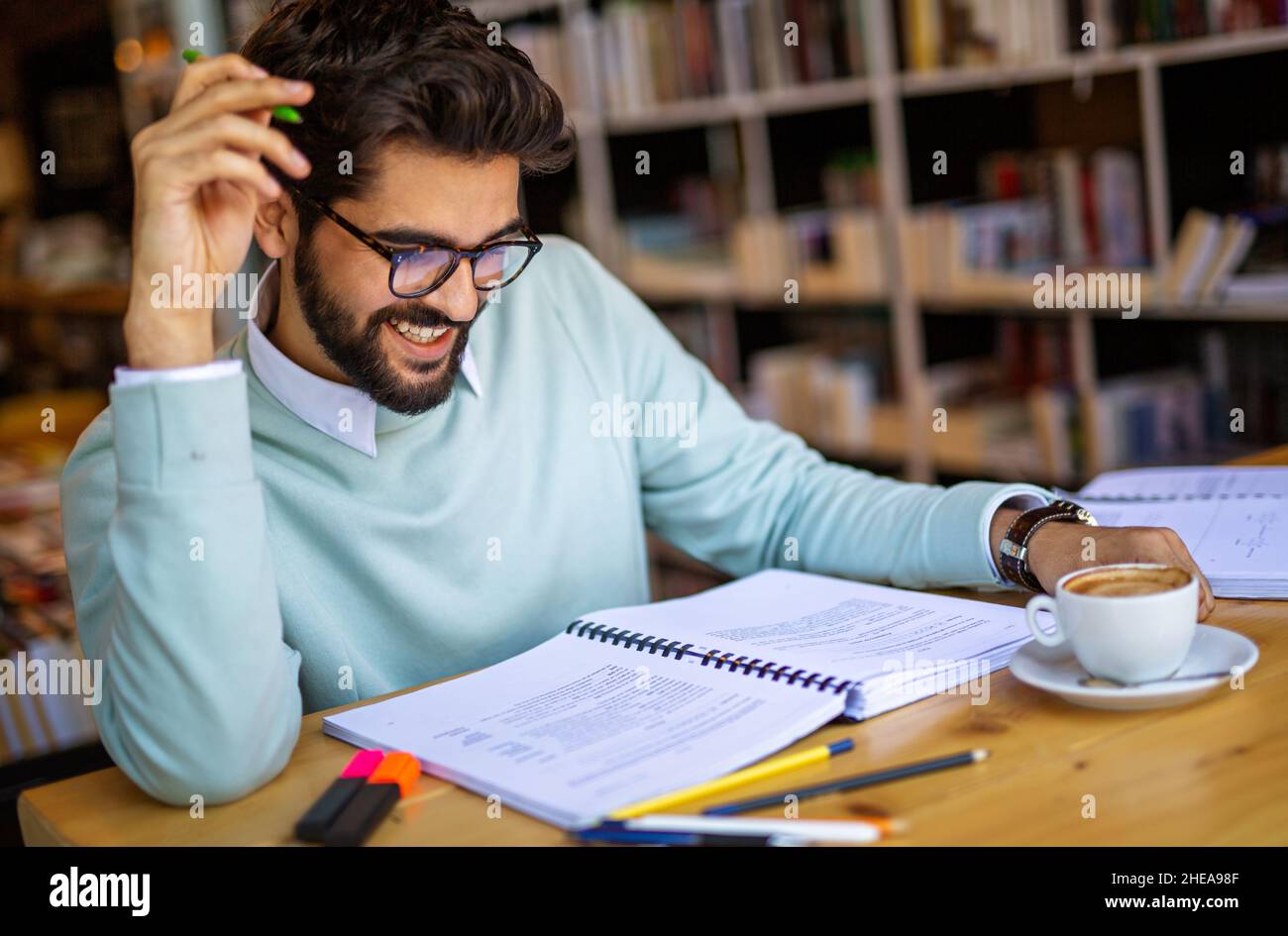 Portrait of young male student studying in a library. Education study ...