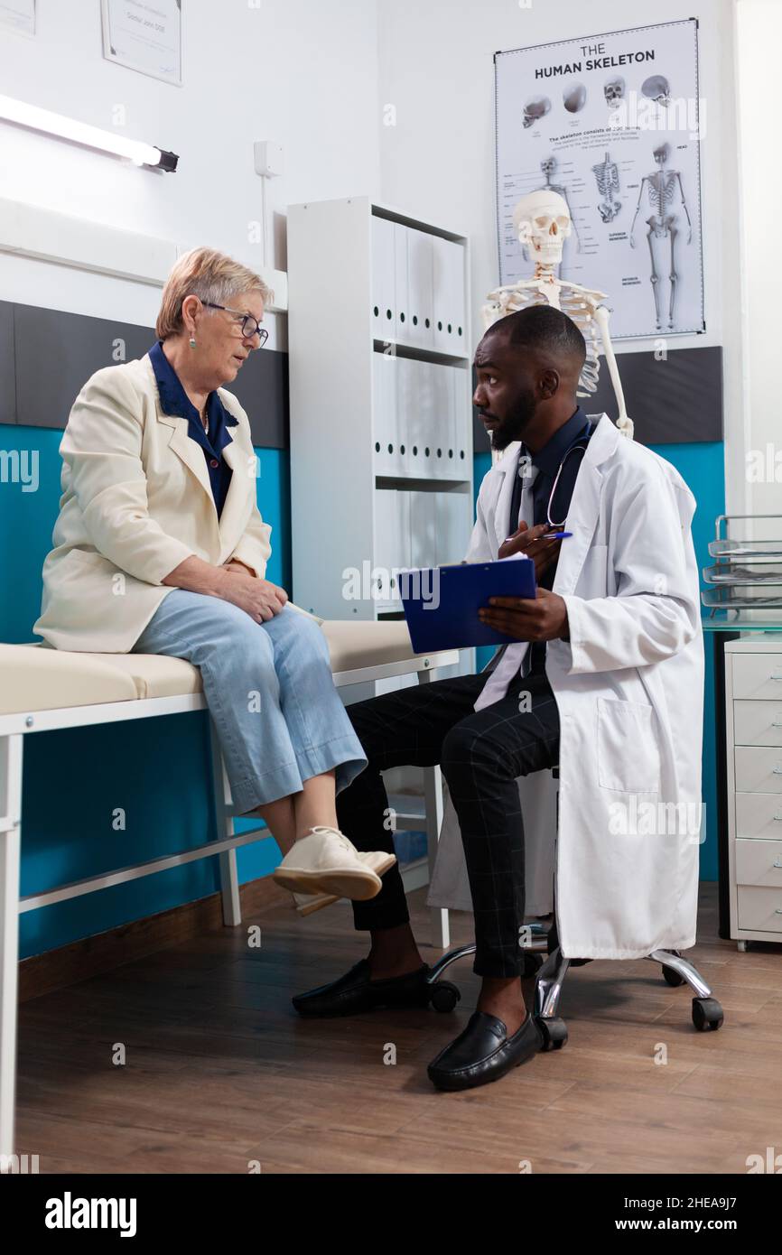 Specialist therapist doctor discussing disease symptoms with senior ...