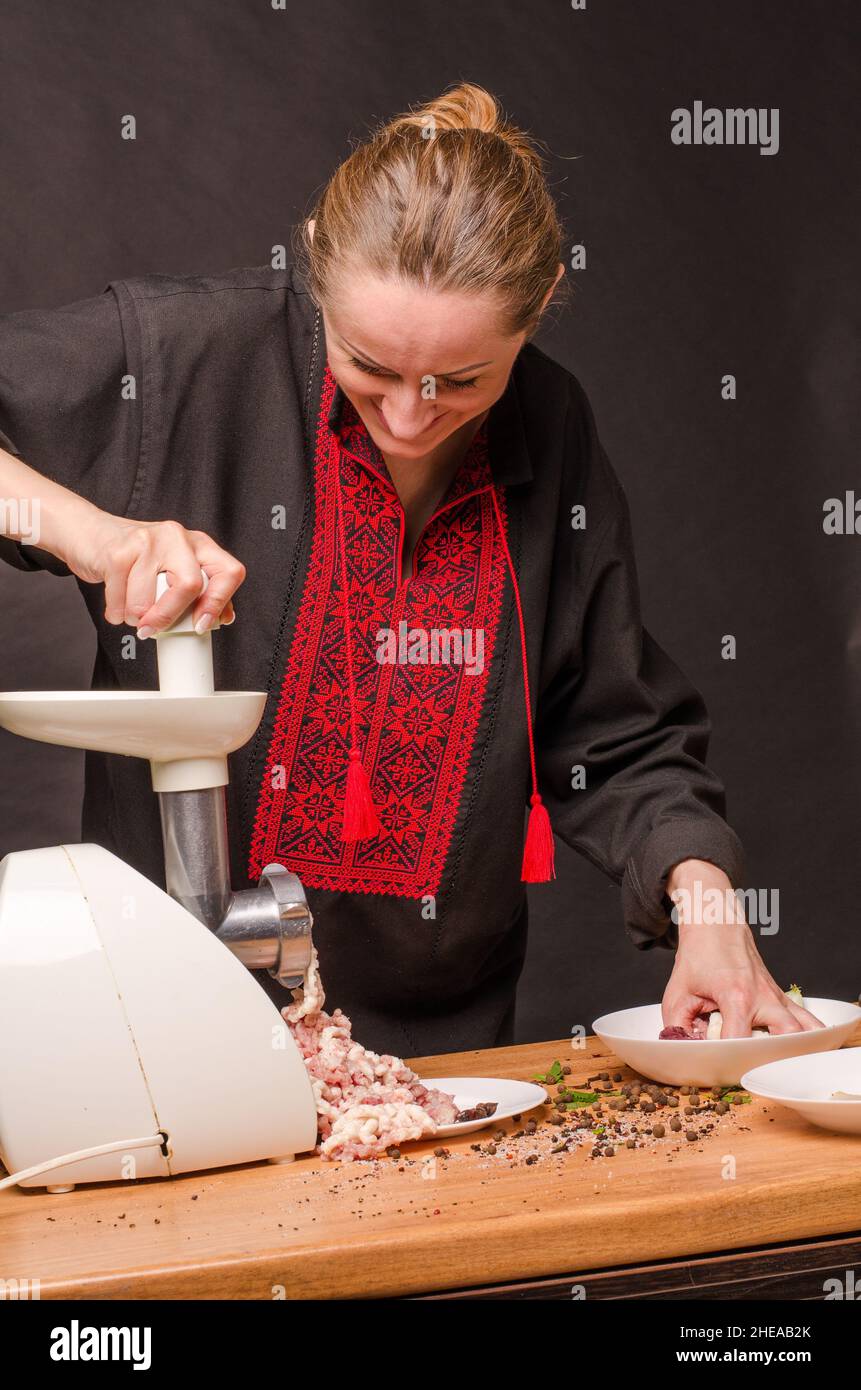 Woman using grinder for preparation of minced meat in kitchen Stock ...
